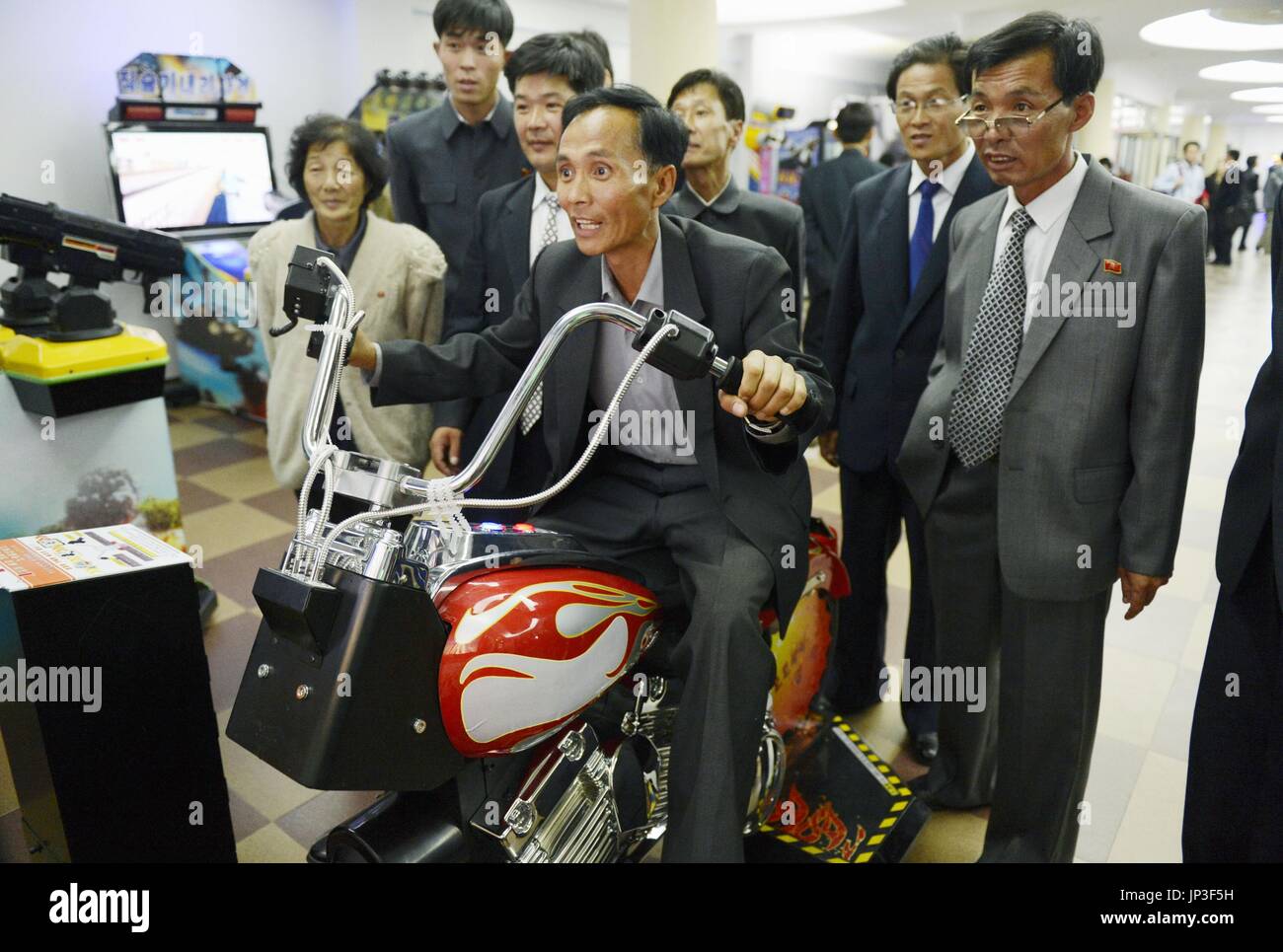 PYONGYANG, North Korea - People gather around a man playing a ...