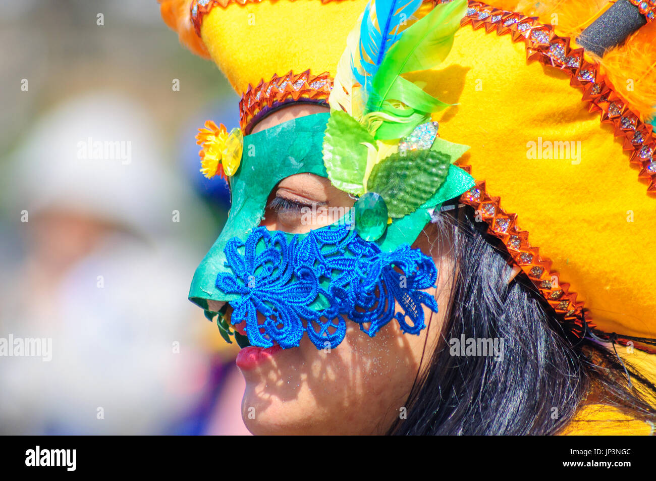 Female performer wearing a colorful costume and mask in the parade on ...