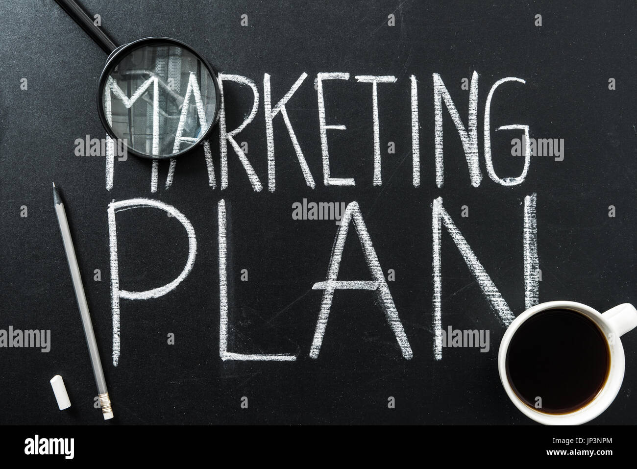 Top view of marketing plan lettering on chalkboard with cup of coffee ...