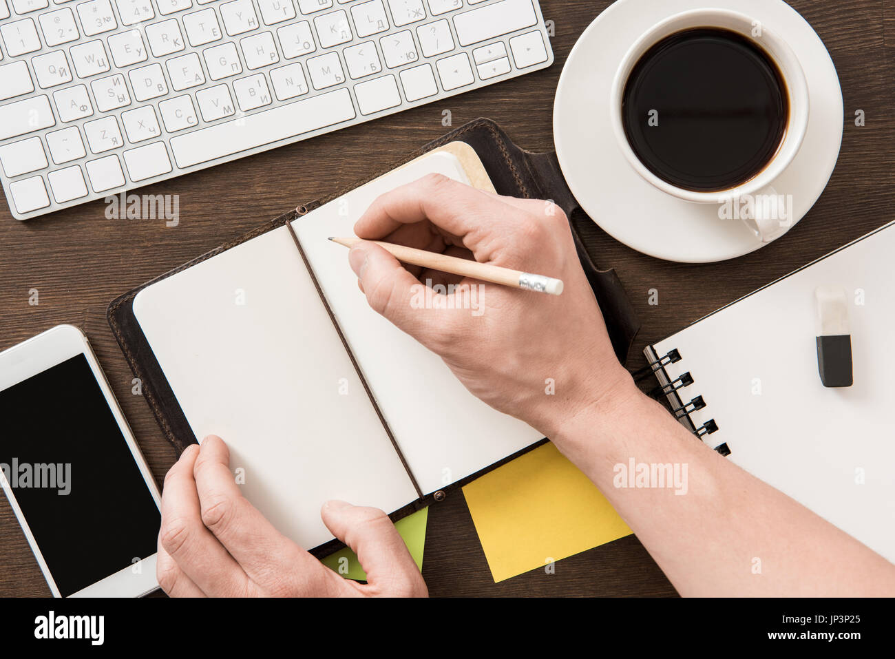 top view of man writing in notebook on home office table Stock Photo ...