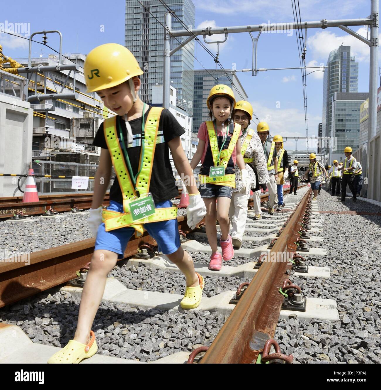 TOKYO, Japan - Children walk on an elevated railroad track of the ...