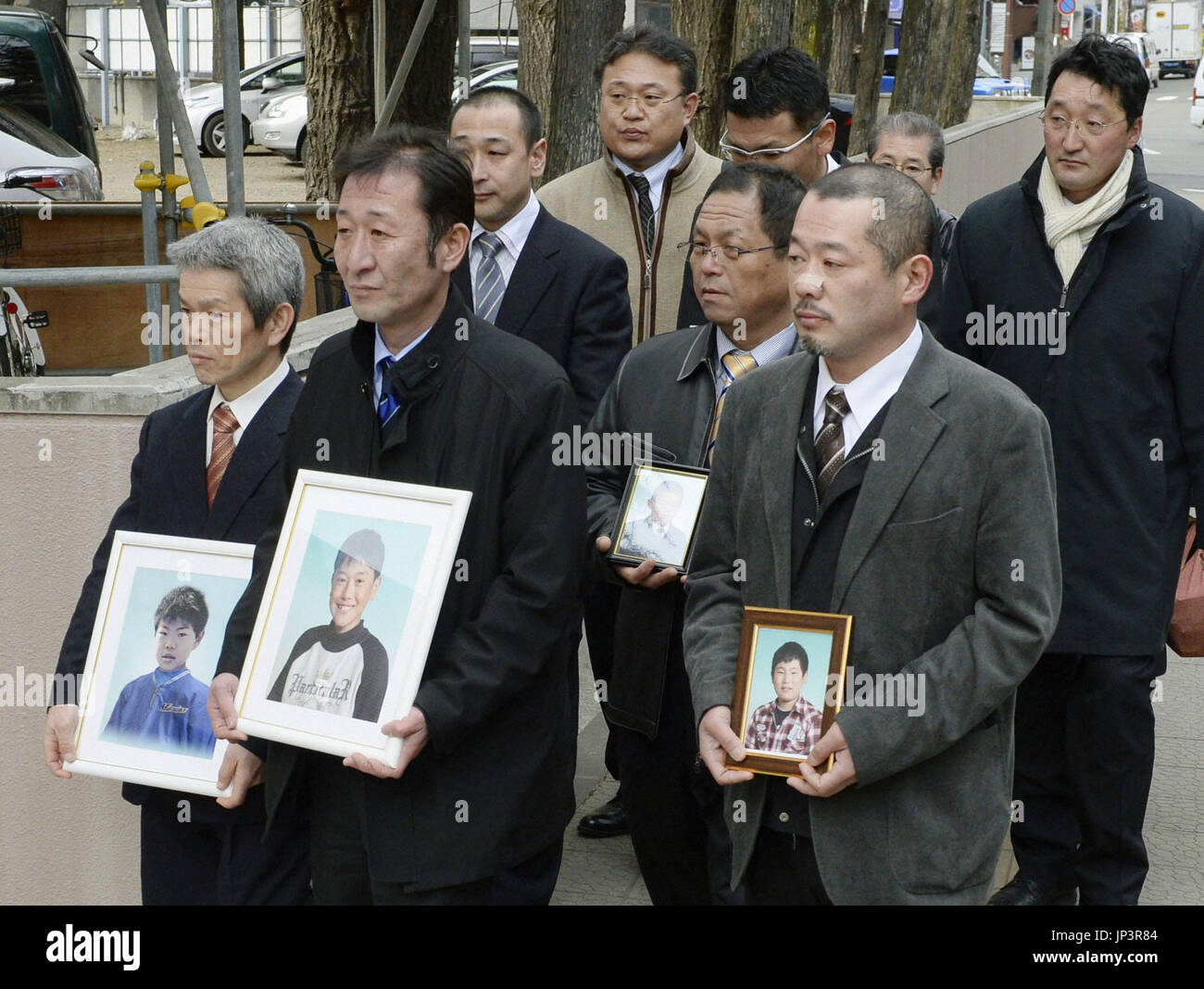 SENDAI, Japan - Relatives hold portraits of dead children as they enter ...