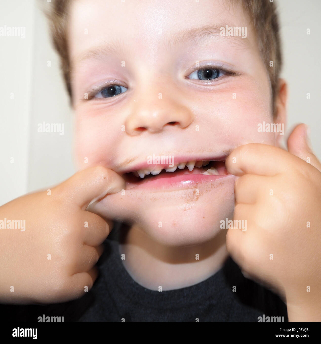 Boy pulling faces to camera Stock Photo - Alamy
