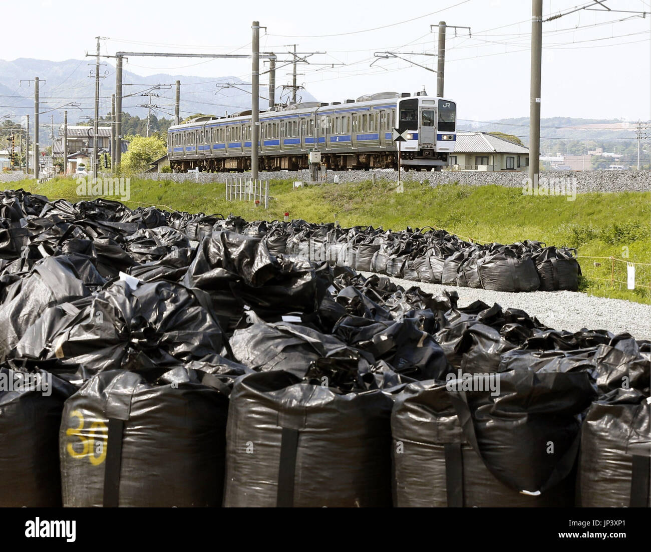 FUKUSHIMA, Japan - A train runs near a radioactive waste storage yard ...