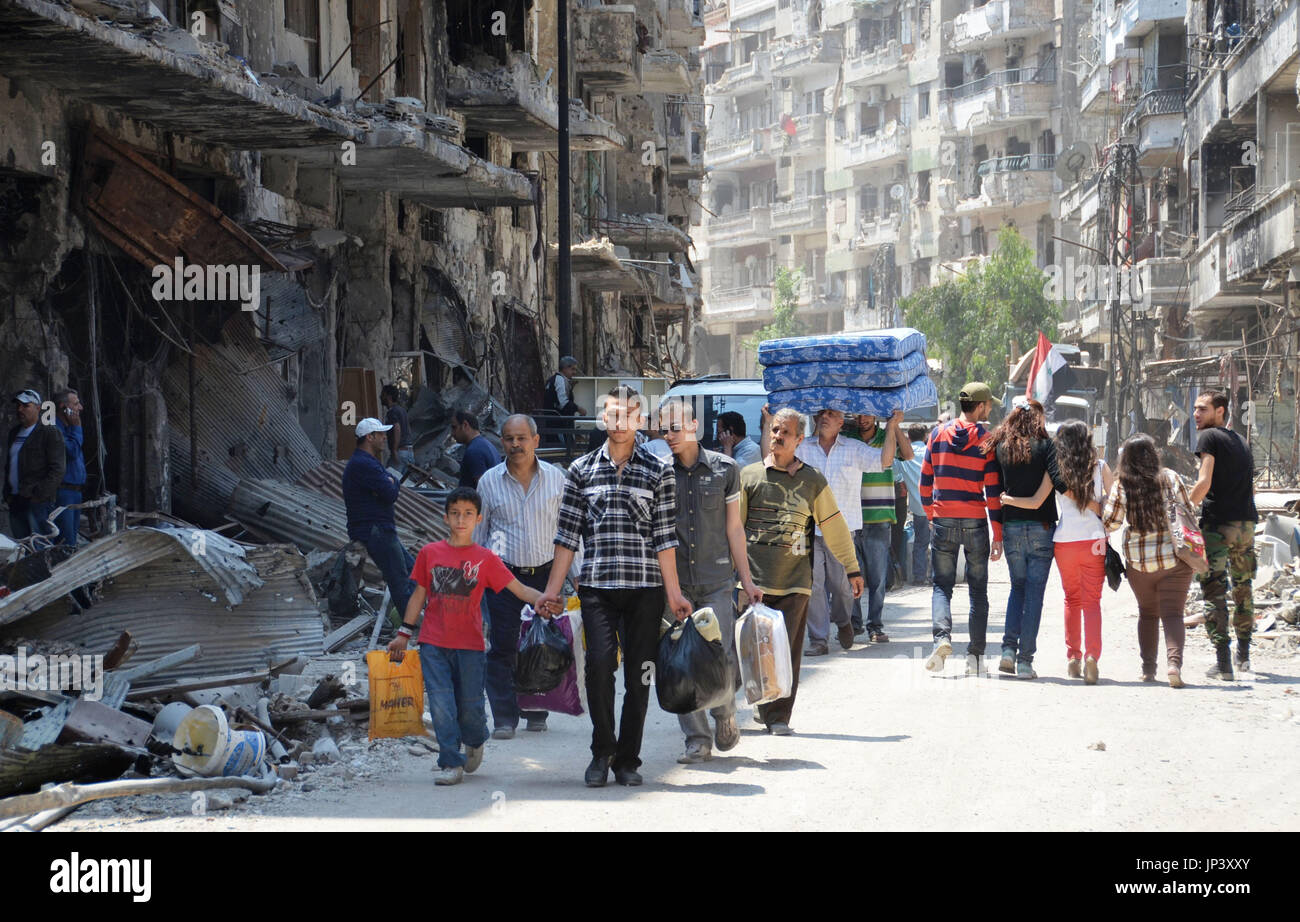 HOMS, Syria - People carry their belongings in war-devastated Homs ...