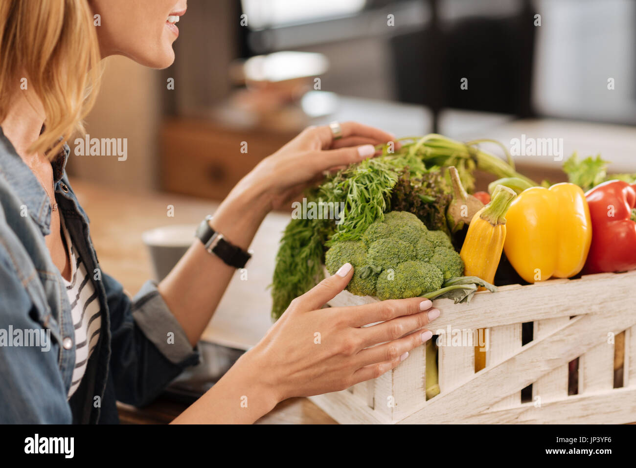 Creative curious woman taking vegetables from the box Stock Photo - Alamy