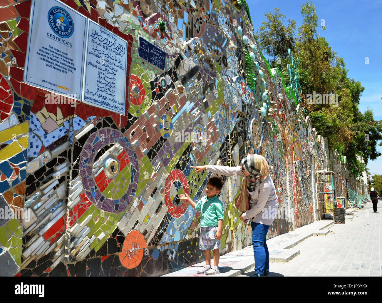 DAMASCUS, Syria - A mother and her boy look at a decorated wall ...