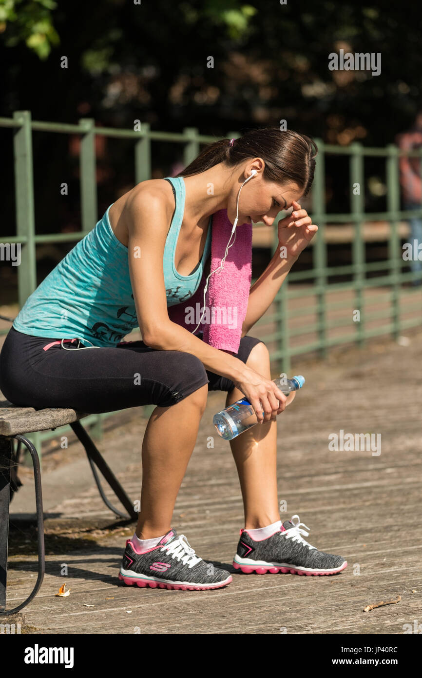 Female runner take a rest seat on the bench Stock Photo - Alamy