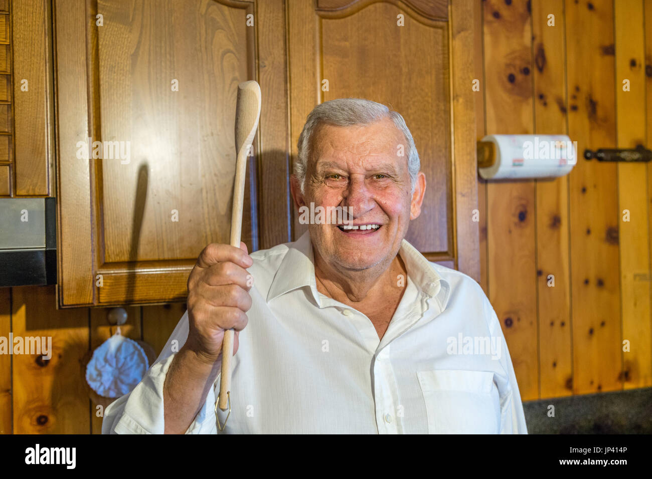 elderly man holding wooden cooking spoon while smiling in vintage ...