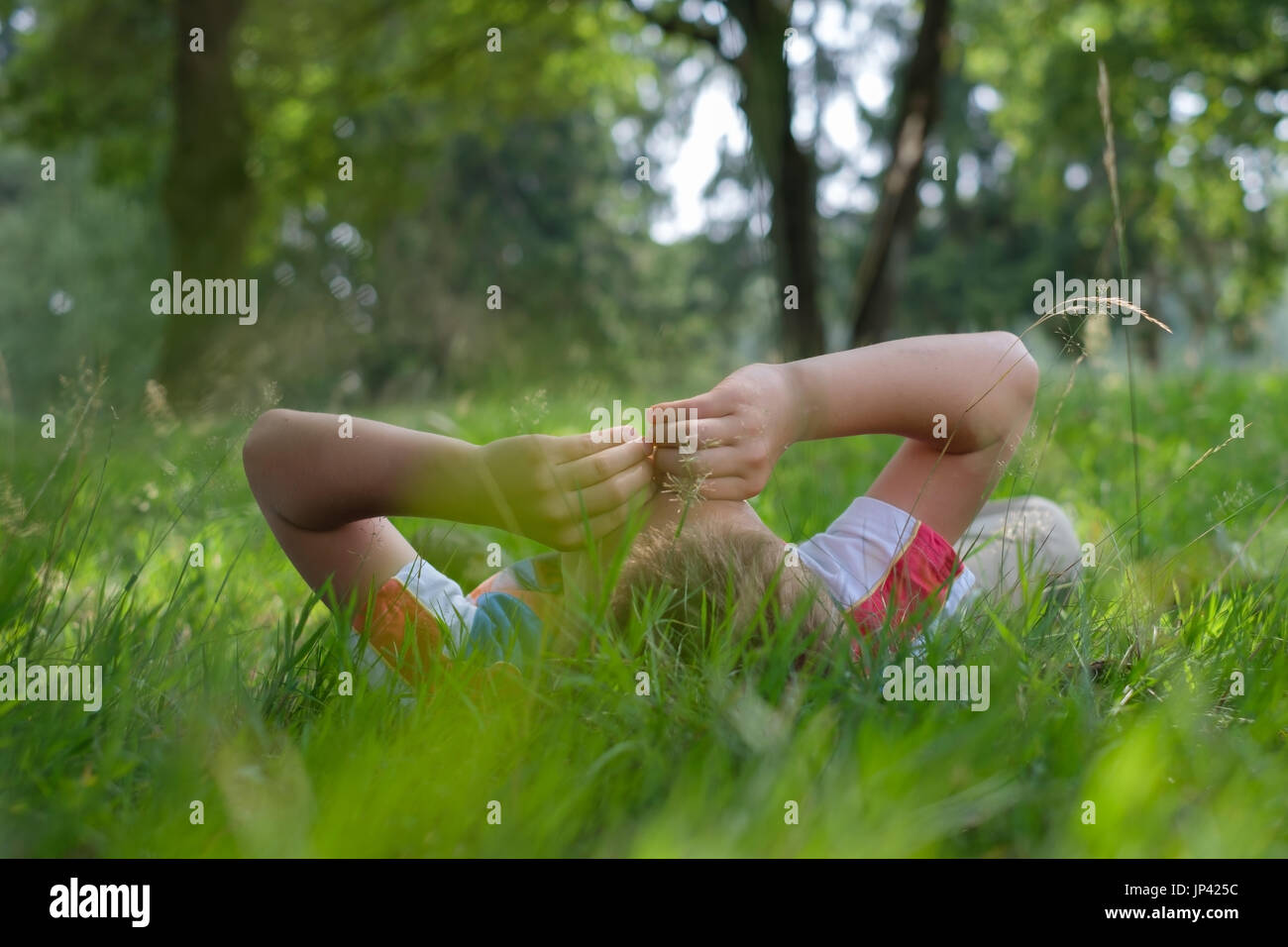 Boy lying on grass hi-res stock photography and images - Alamy