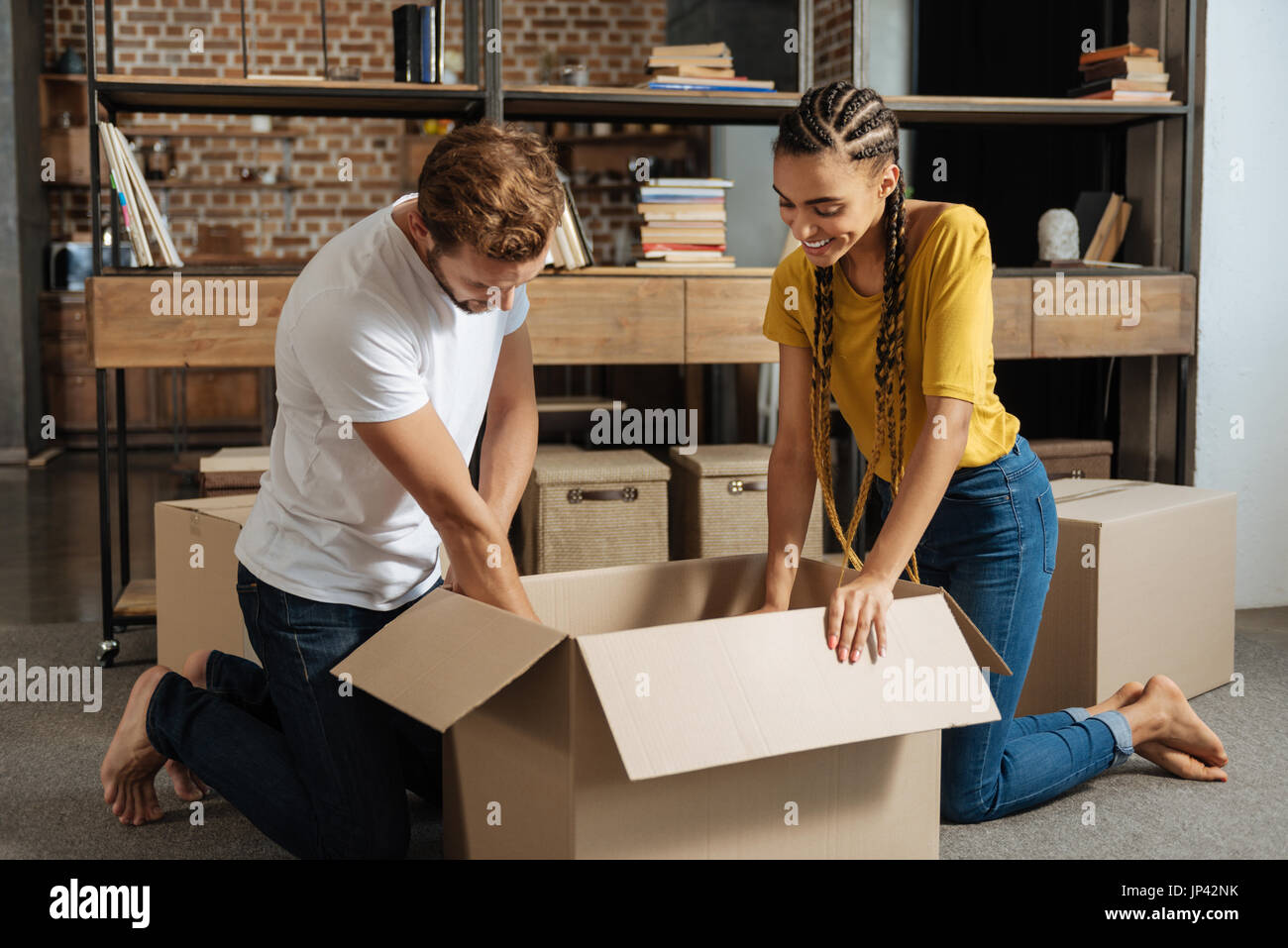 Positive delighted woman with braids helping her man Stock Photo - Alamy
