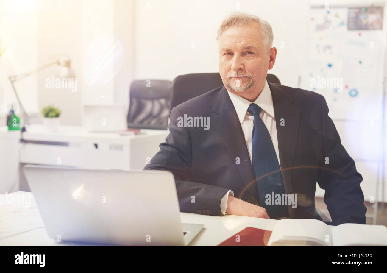Charming middle aged man sitting in his office Stock Photo - Alamy