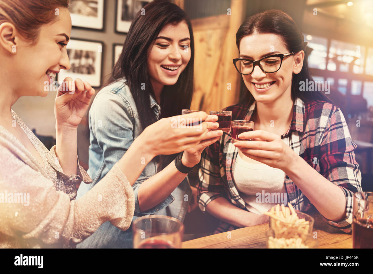 Smiling girls going to drink tasty alcohol Stock Photo - Alamy