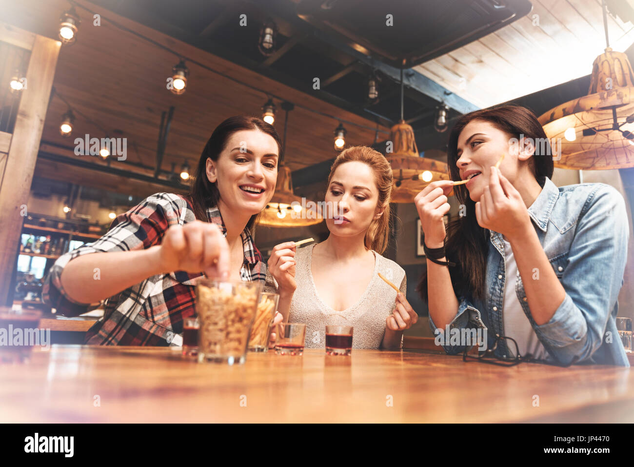 Attractive girls that eating snacks in pub Stock Photo - Alamy