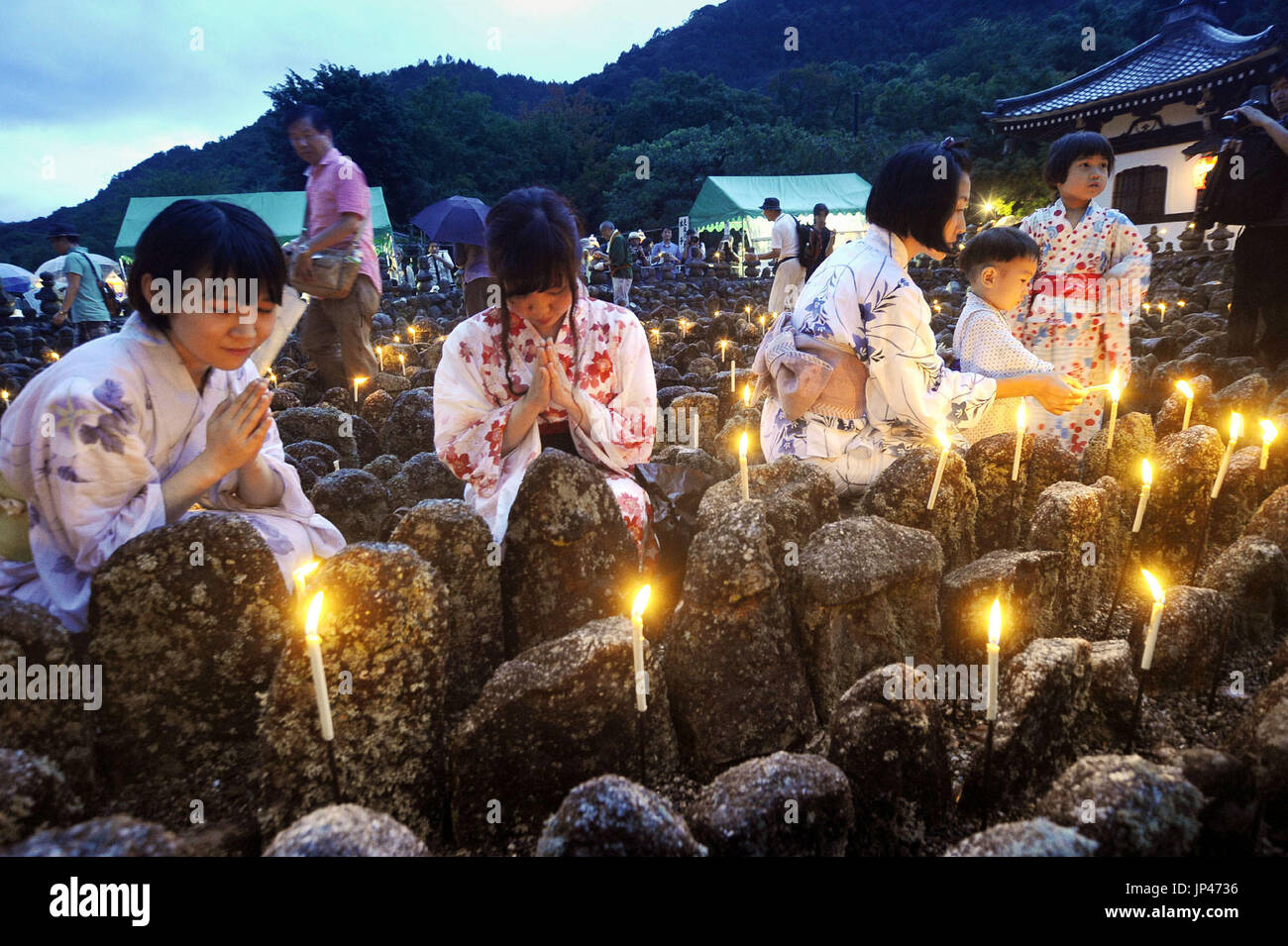 KYOTO, Japan - People pray before candlelit stone Buddha statues and ...