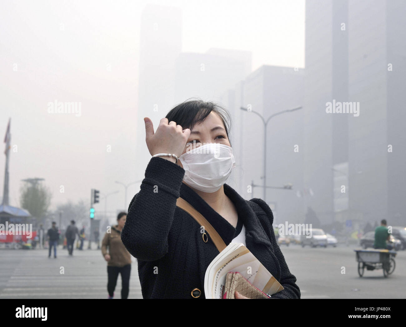 BEIJING, China - A woman wears a mask due to severe air pollution in ...