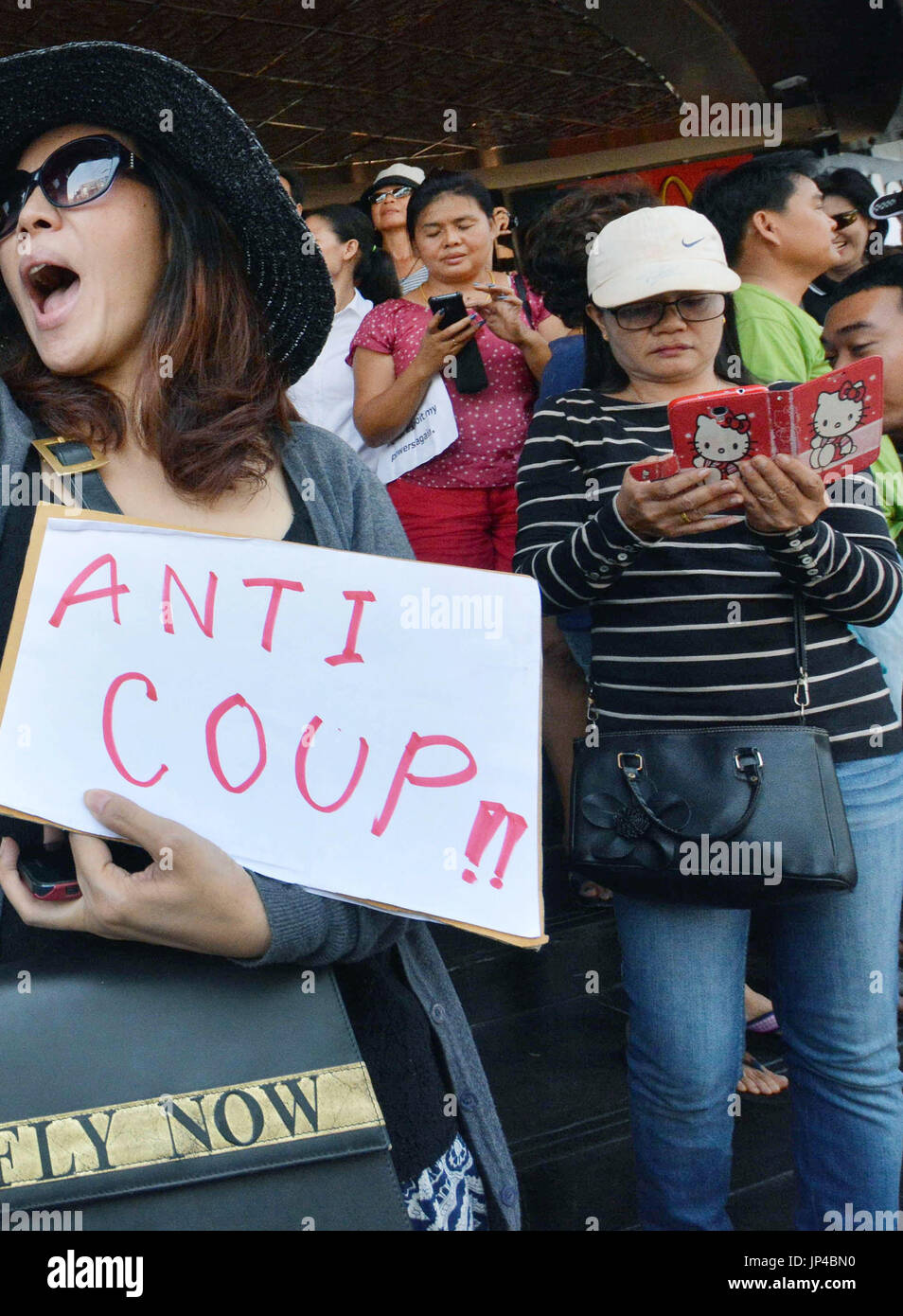 BANGKOK, Thailand - Women look at their mobile phones during an anti ...