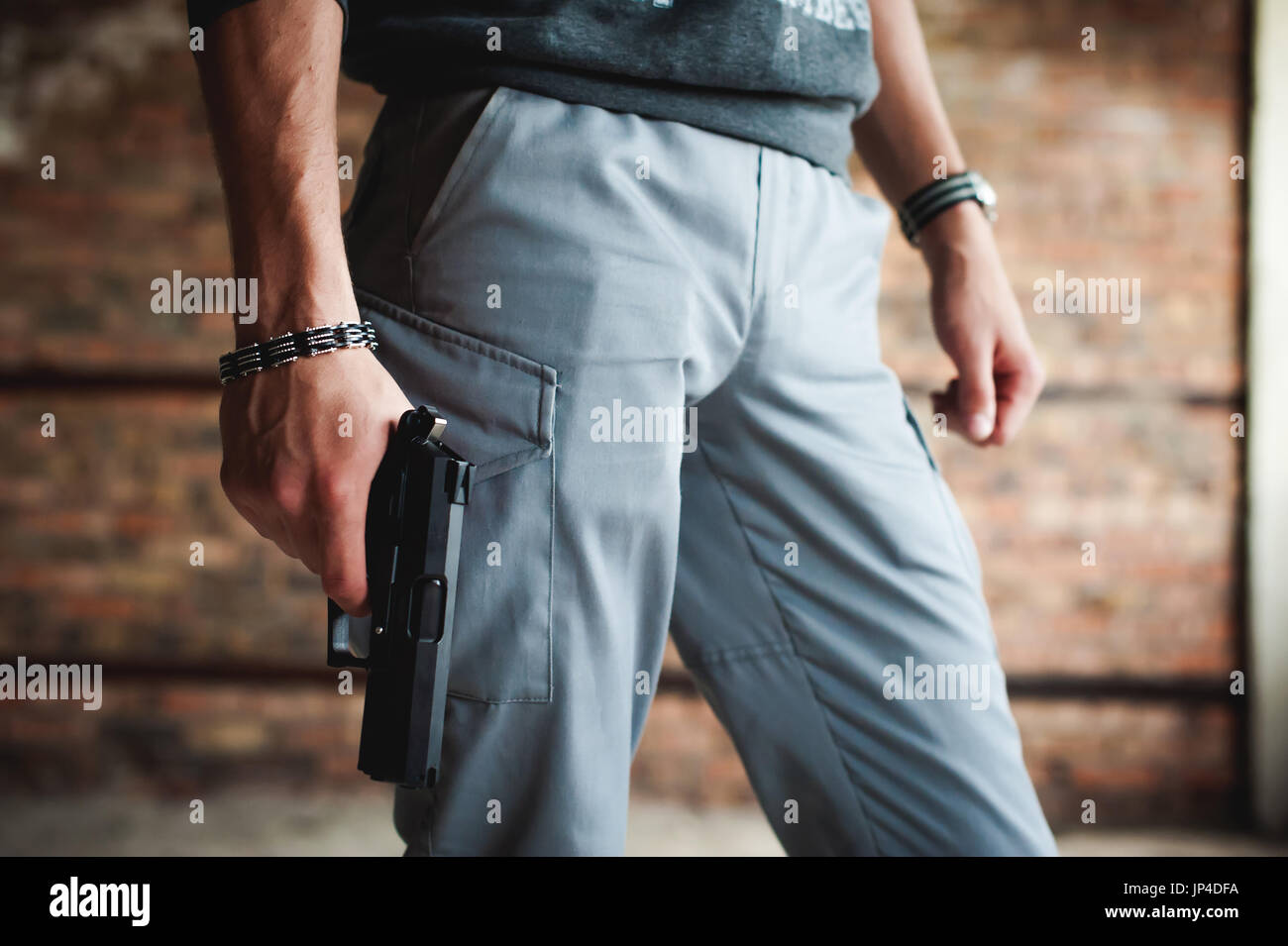 athletic man holding a gun in his hand on the ready Stock Photo - Alamy