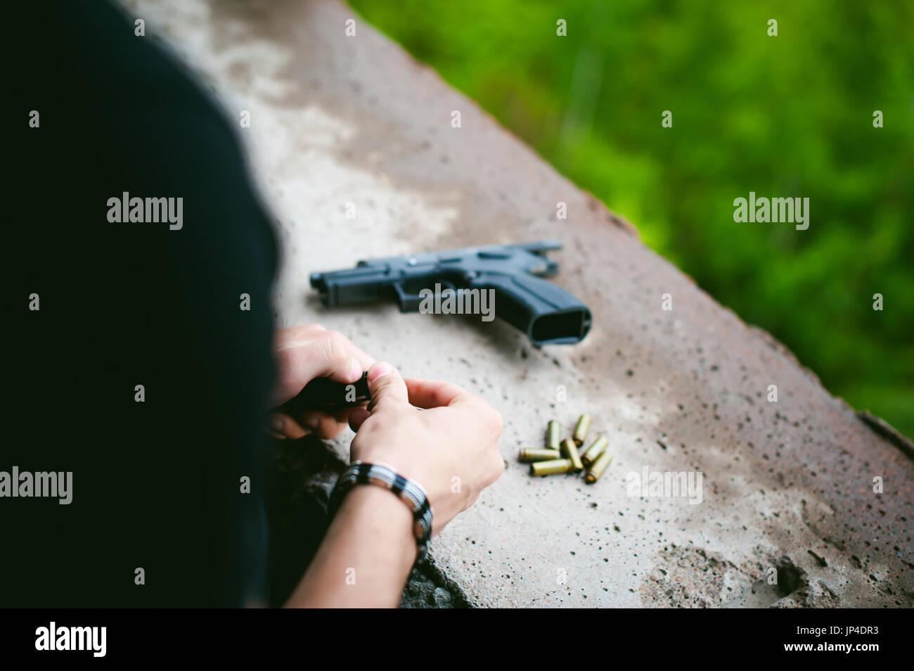 Man charges clip of pistol with bullets. Photo hands of paramilitary ...