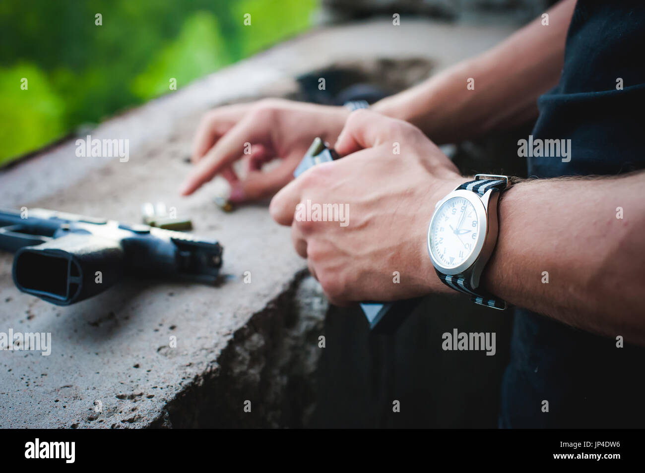 Man charges clip of pistol with bullets. Photo hands of paramilitary ...