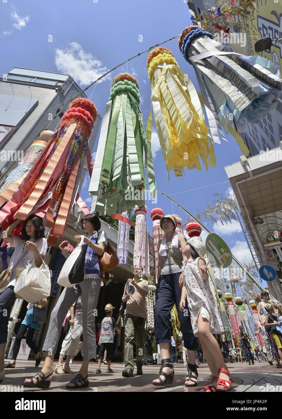 SENDAI, Japan - People walk under colorful streamers at a shopping ...