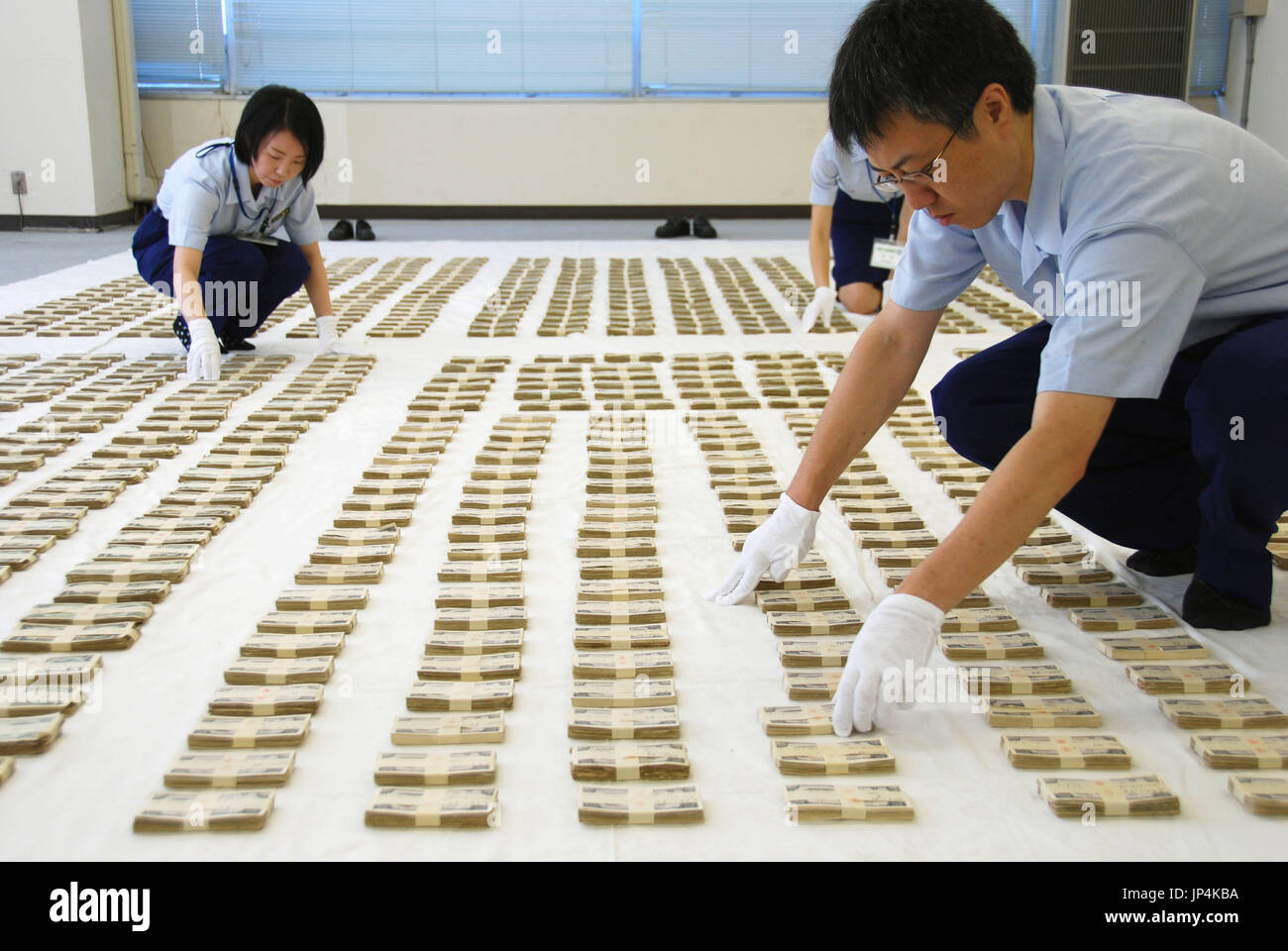 YOKOHAMA, Japan - Customs officials expose to the air excess bank notes ...