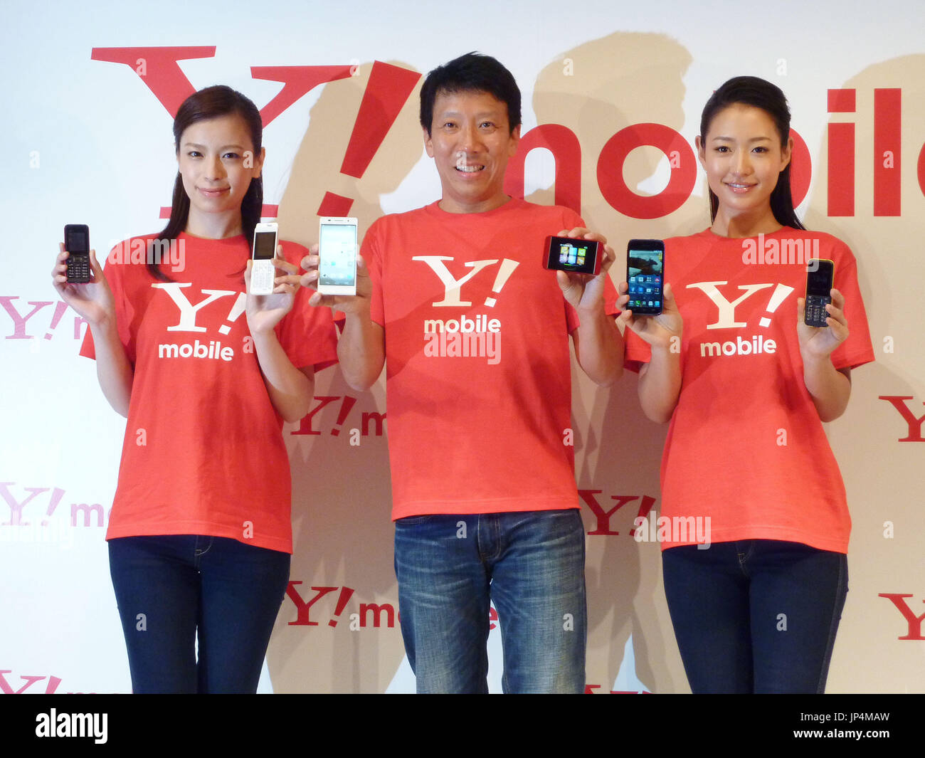 TOKYO, Japan - Ymobile Corp. President Eric Gan (C) shows off new ...
