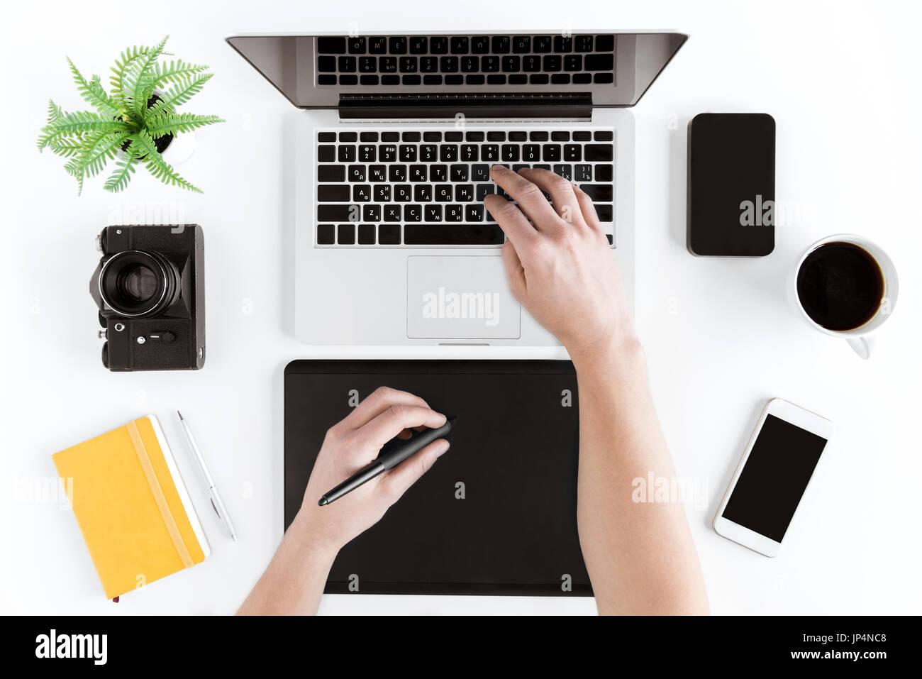 top view of hands using graphic tablet and laptop at modern workplace ...