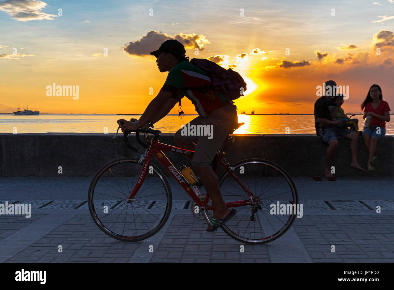 Cyclist at sunset on Manila Bay, Philippines Stock Photo - Alamy