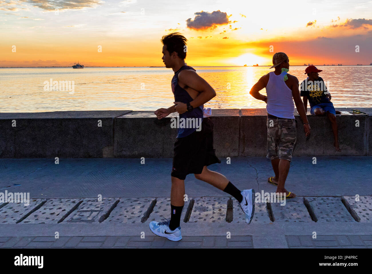 Jogger at sunset on Manila Bay, Philippines Stock Photo - Alamy