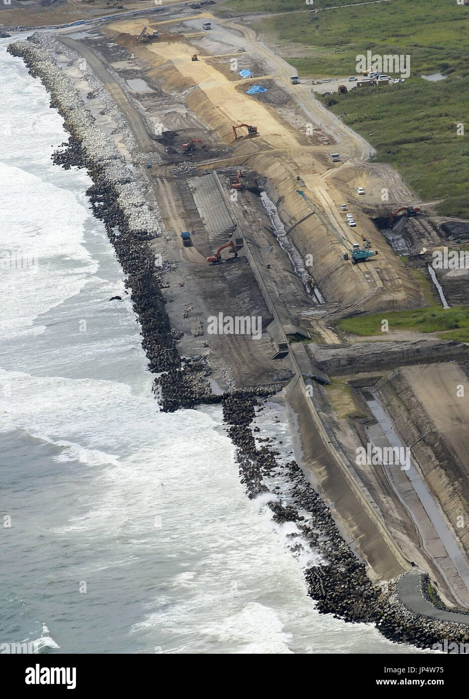 TOKYO, Japan - Construction of a coastal levee is under way on a beach ...