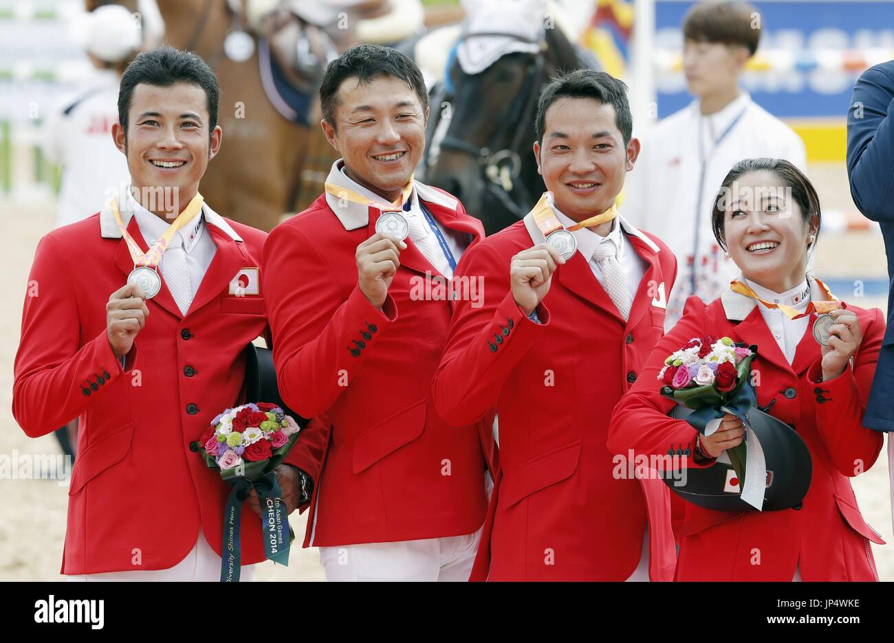 INCHEON, South Korea - Japanese equestrians smile as they show off their silver medals in the ...