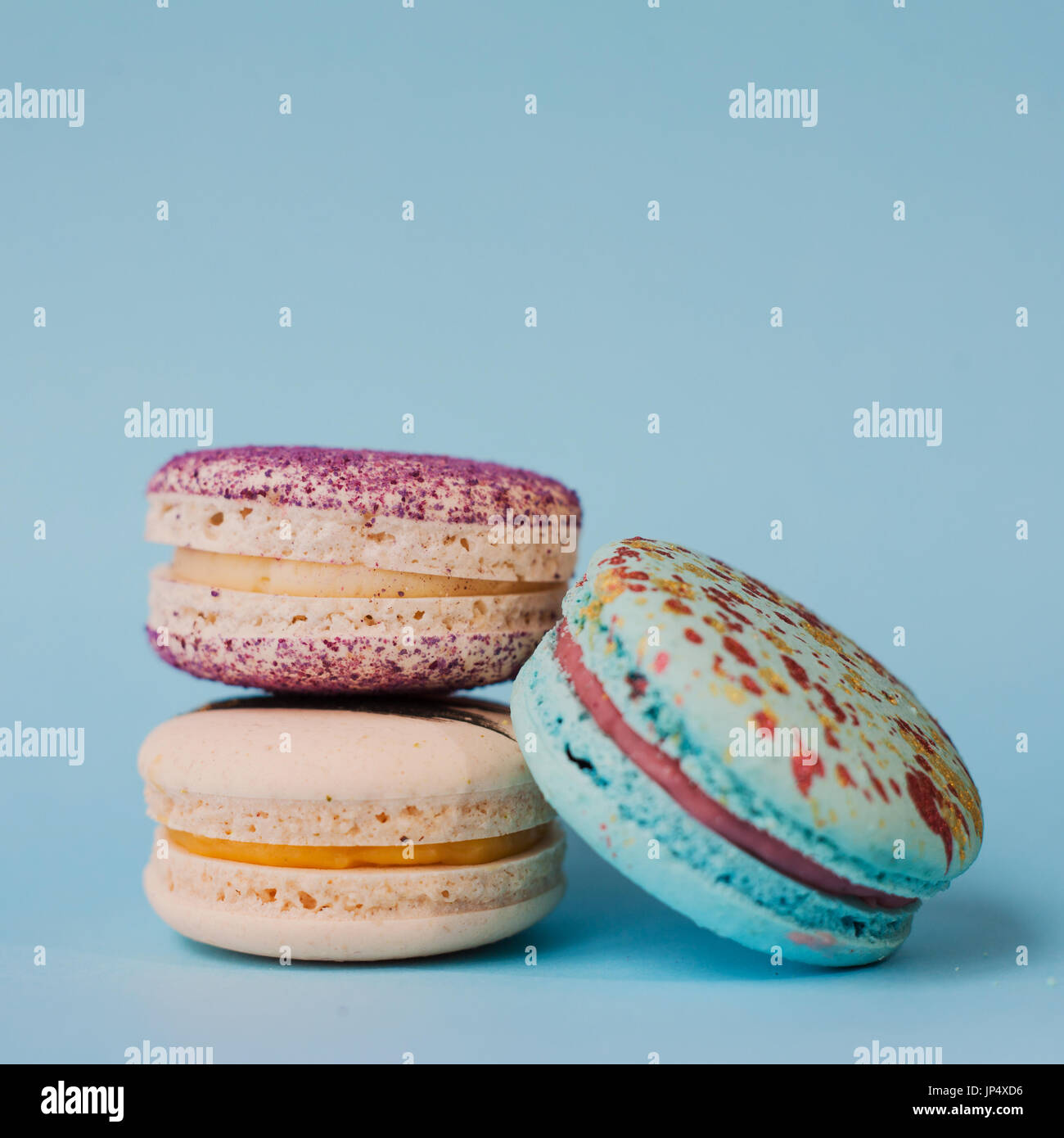 Different types of macaroons on blue background Stock Photo - Alamy