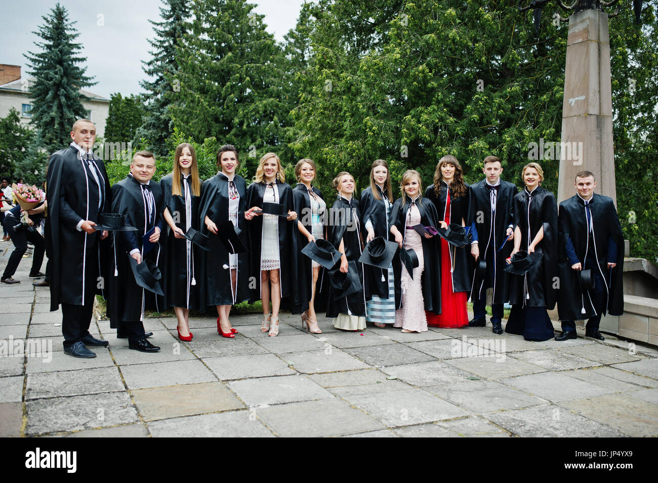 Huge group of graduates in graduation gowns and caps posing outdoor ...