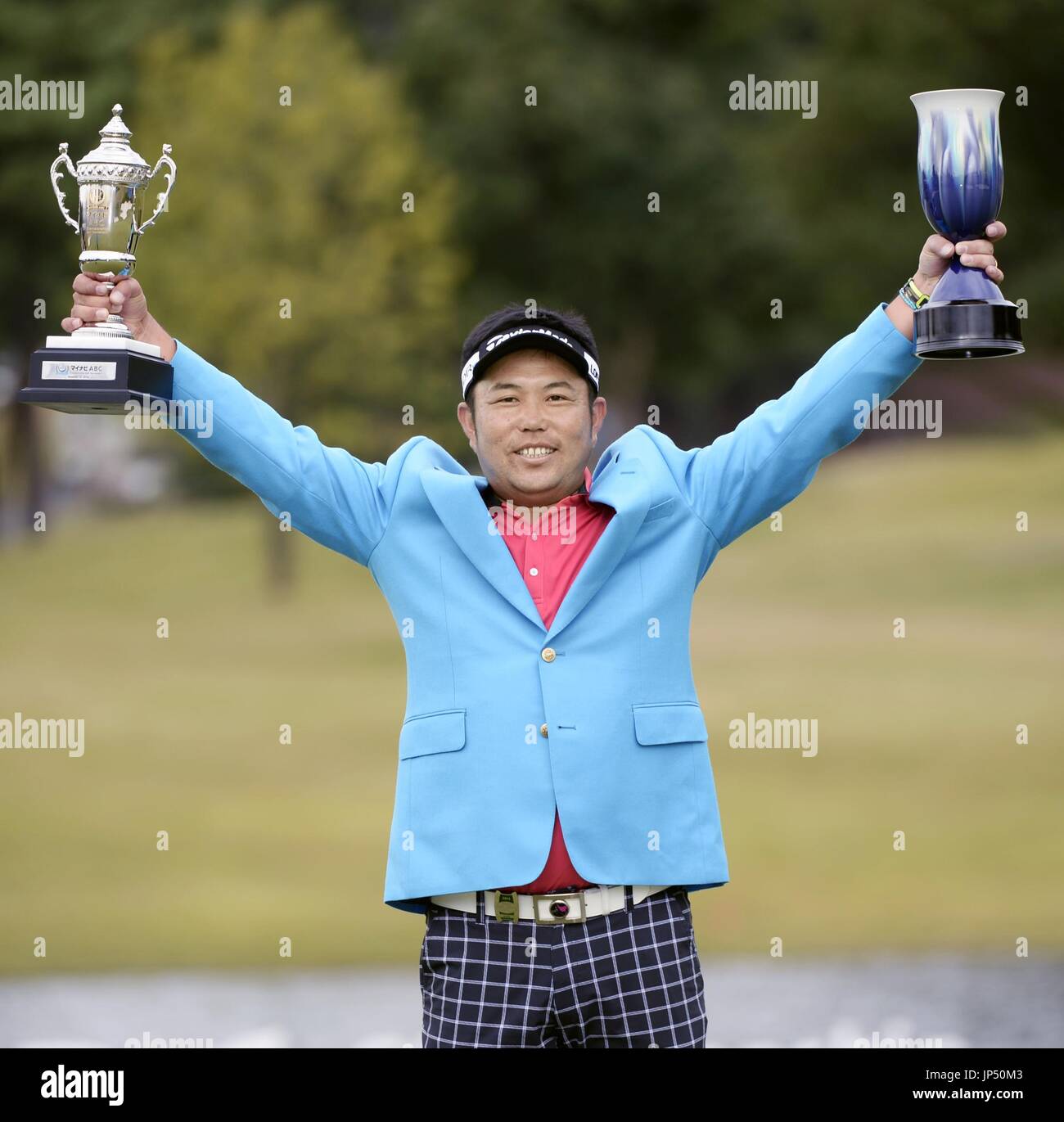 KATO, Japan - Ryuichi Oda holds up the winner's trophies after his ...