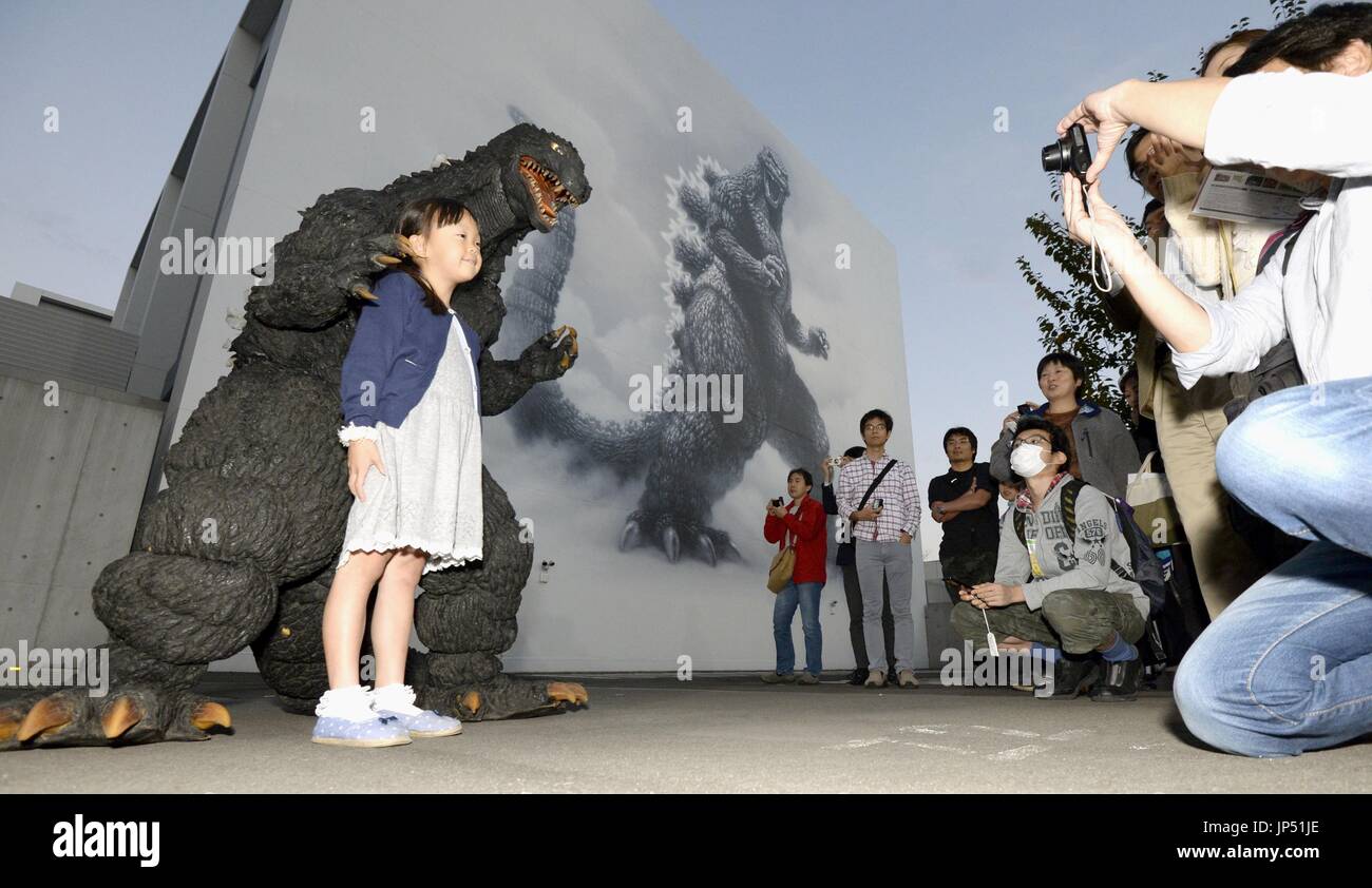TOKYO, Japan - A child poses with an actor in "Godzilla" suit for a ...