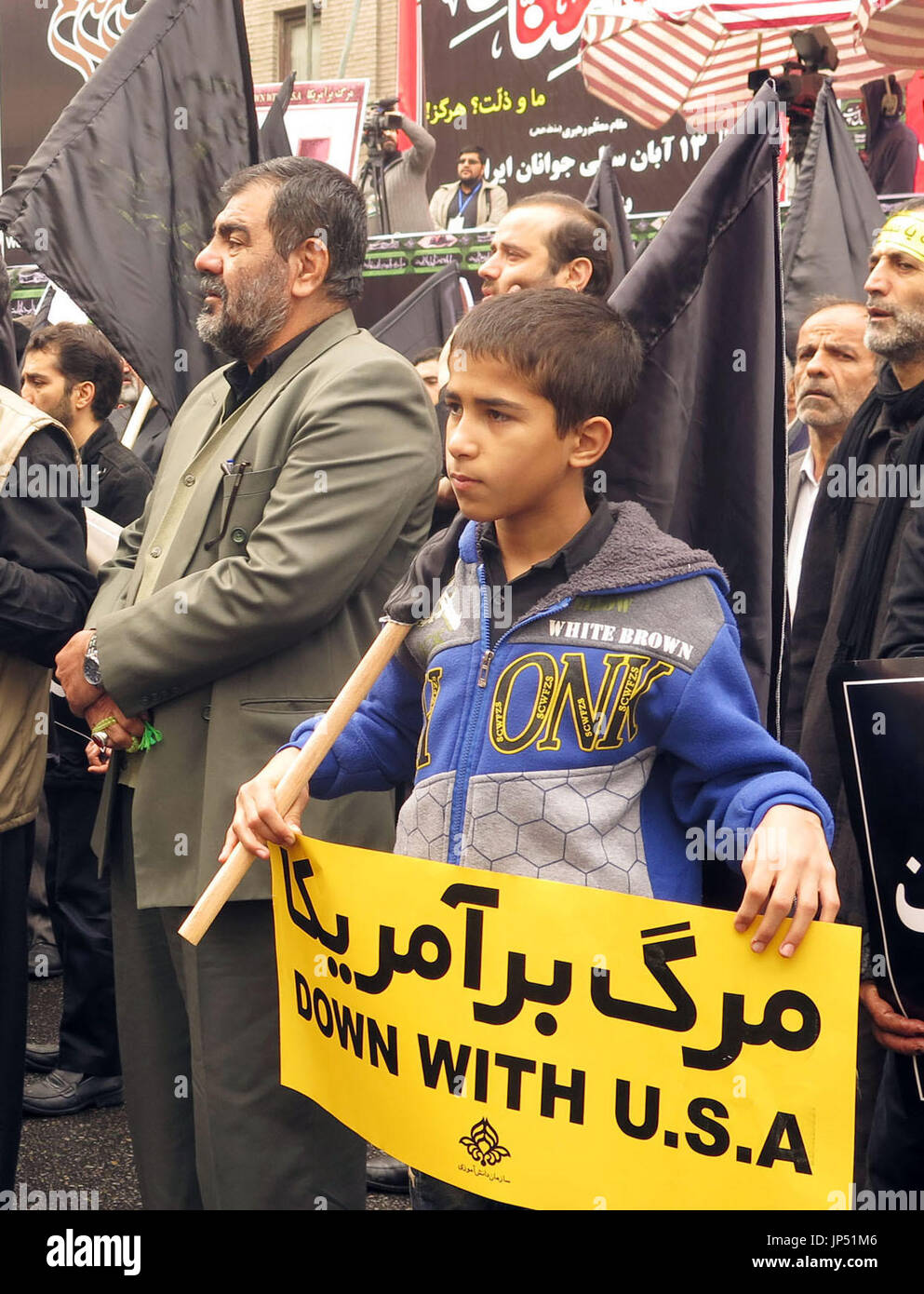TEHRAN, Iran - An Iranian boy with an anti-U.S. placard listens to a ...