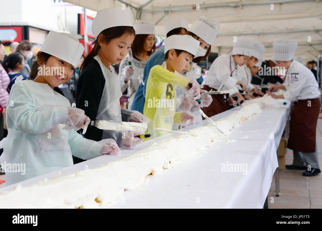 OSAKA, Japan - People work on making the world's longest cake roll ...