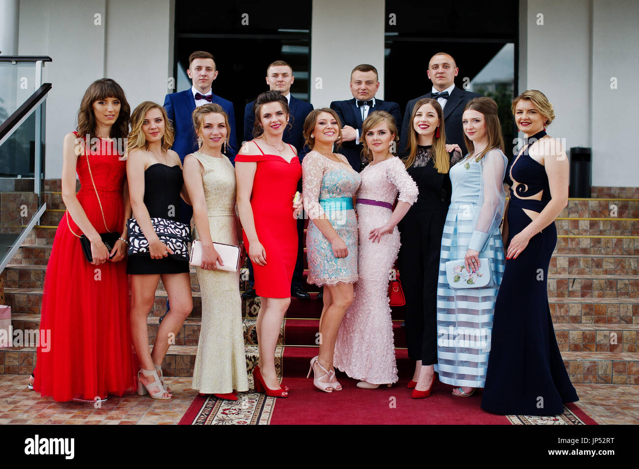 Group of good-looking graduates posing on the graduation day next to ...