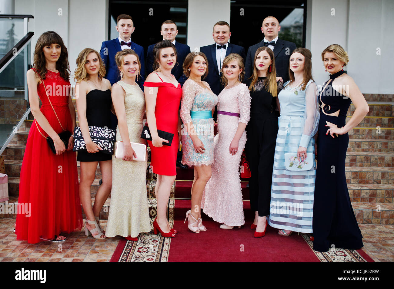 Group of good-looking graduates posing on the graduation day next to ...
