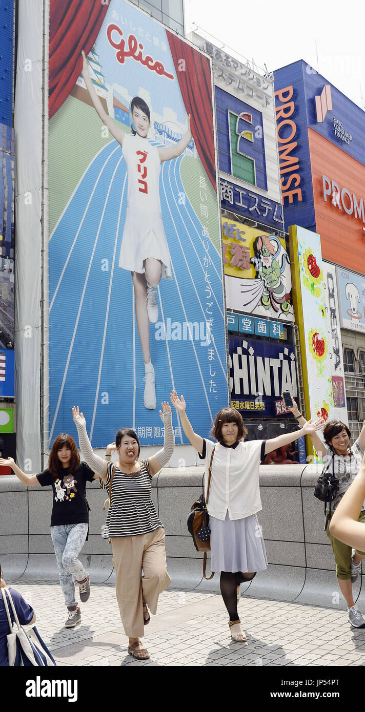 OSAKA, Japan - Women imitate the "one-leg stand" pose of popular ...