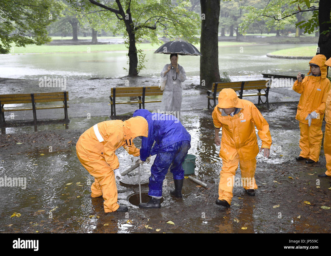 TOKYO, Japan - Workers remove water from a spray pond at Yoyogi Park in ...