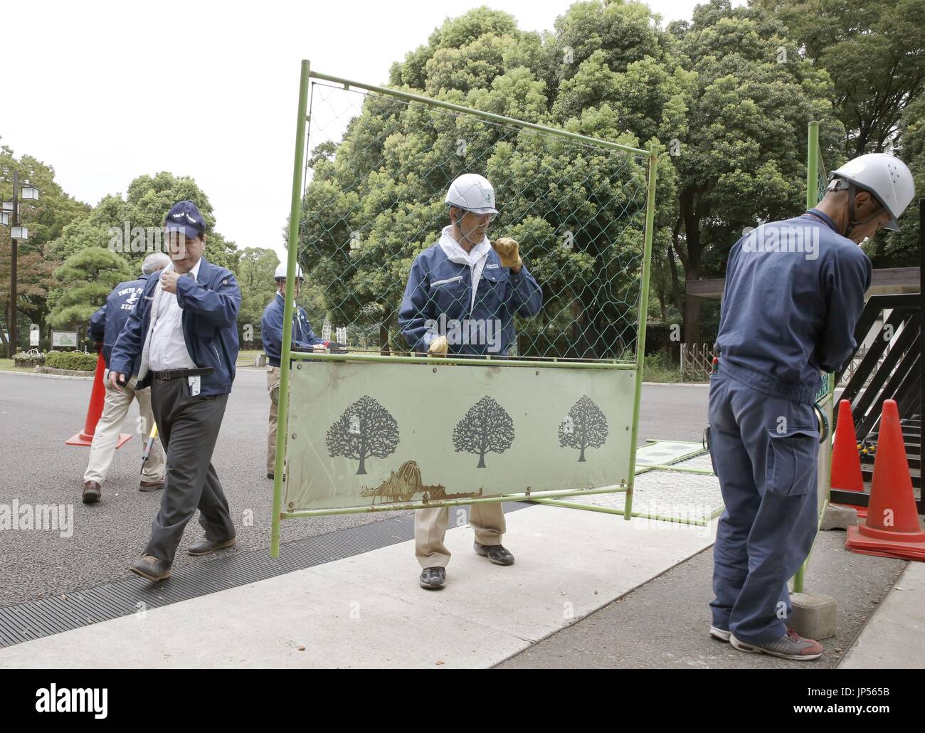 TOKYO, Japan - Workers erect barriers to keep people out of Yoyogi Park ...