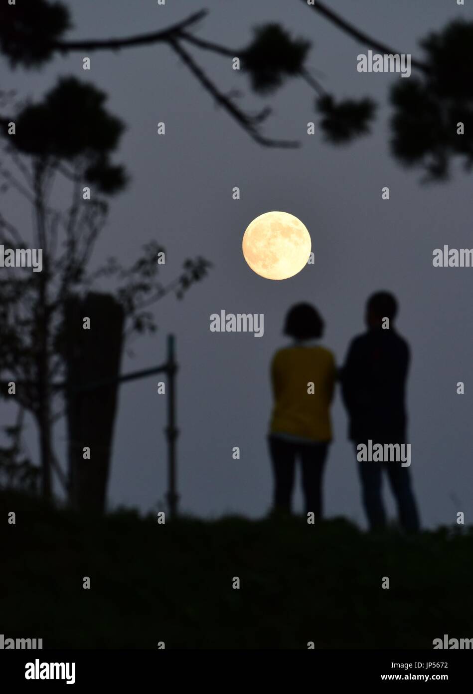 NATORI, Japan - People watch a harvest moon in a coastal area of Natori ...