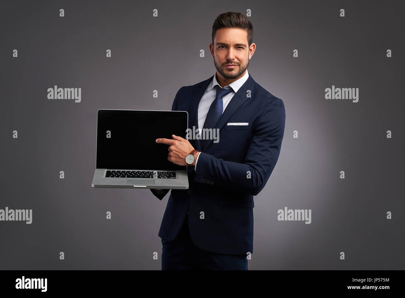 An elegant handsome young man holding and showing the screen of a ...