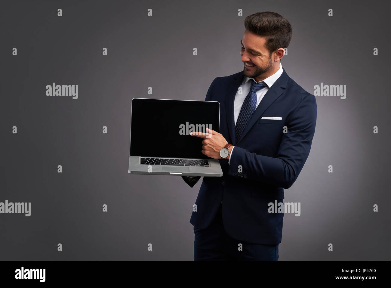 An elegant handsome young man holding and showing the screen of a ...