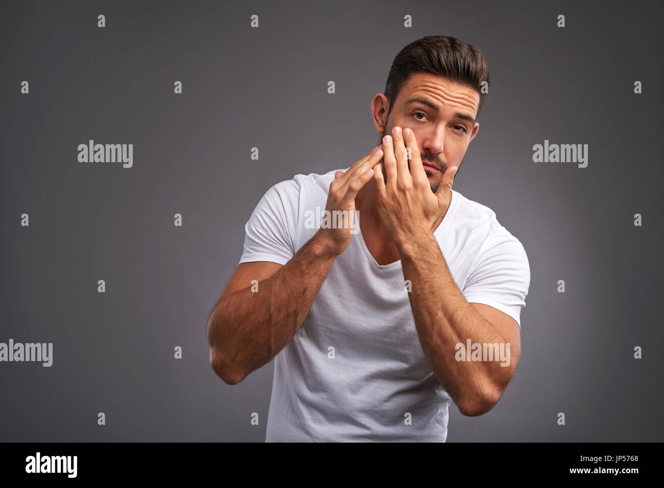 A handsome young man checking the skin on his face Stock Photo - Alamy