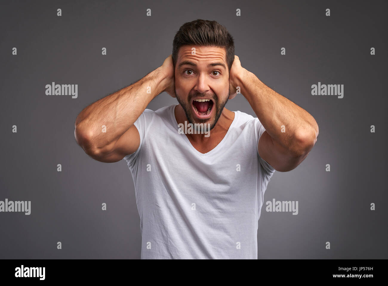 A handsome young man feeling shocked and screaming Stock Photo - Alamy