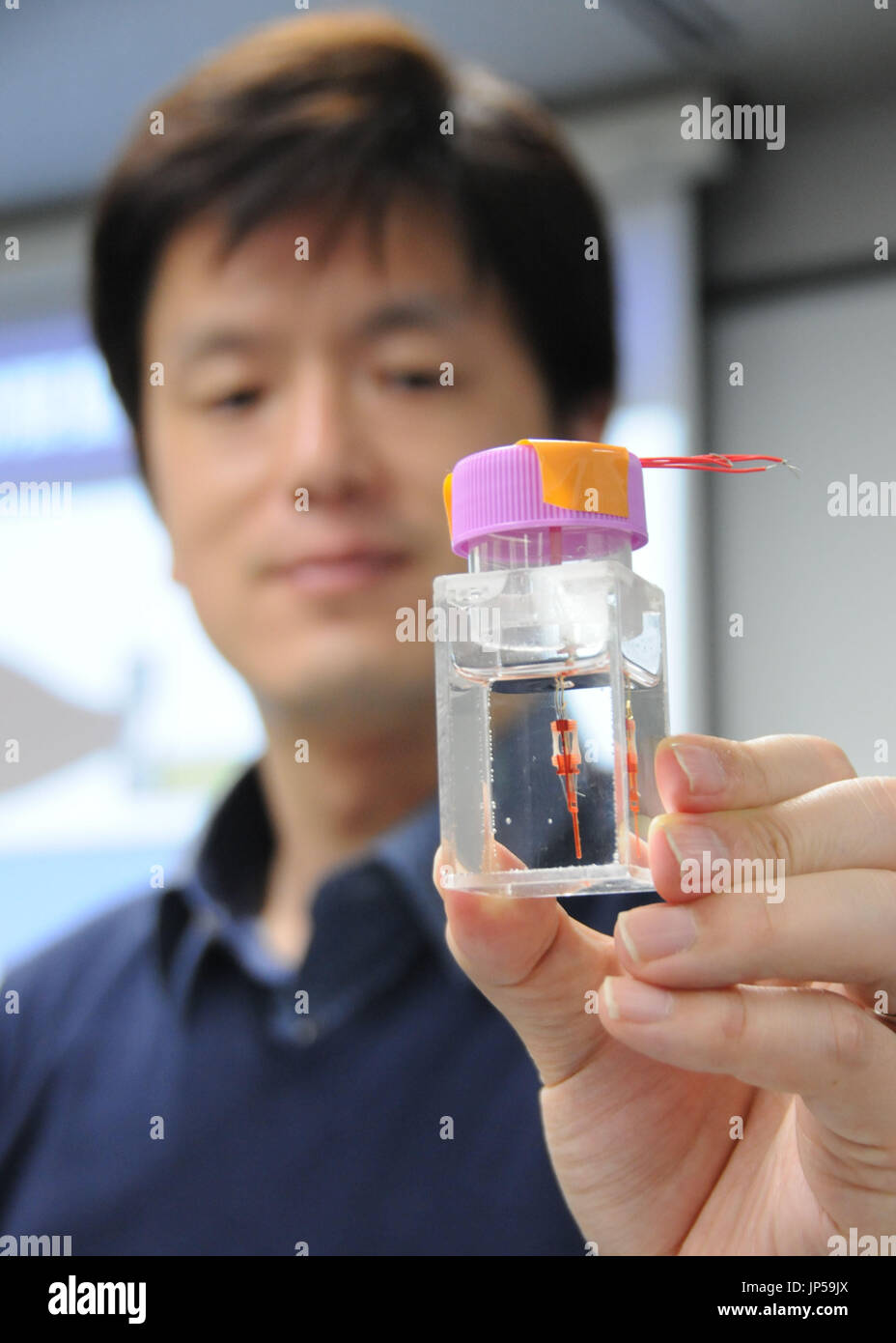TOKYO, Japan - University of Tokyo Professor Shoji Takeuchi holds a ...