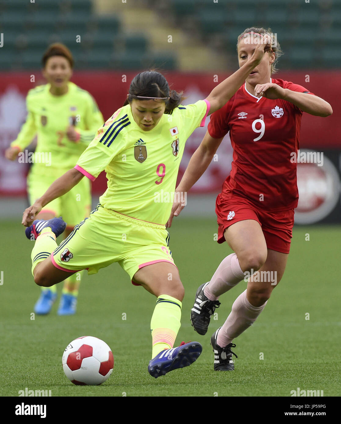 EDMONTON, Canada - Nahomi Kawasumi of Japan (L) kicks the ball as Josee ...
